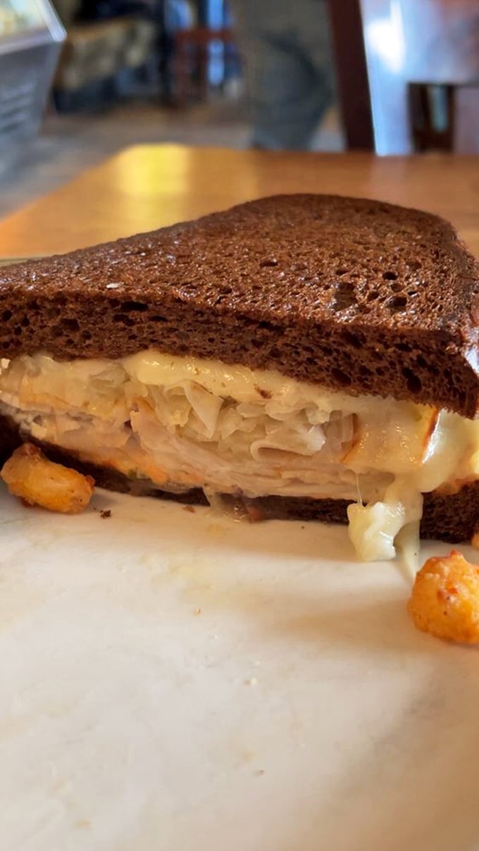 A sandwich that understands balance – hearty rye, tangy sauerkraut, and cheese that doesn't just participate but leads the flavor parade.