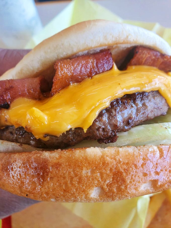 That cheese melt is performing a slow, seductive dance over the patty while bacon stands guard. A burger that demands respect—and napkins.