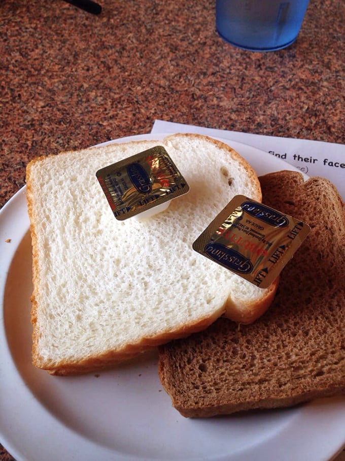 White bread with butter packets—the humble palate cleanser between bites of intensely flavorful chicken that somehow feels exactly right.