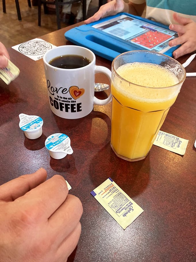Morning negotiations require proper fuel—a mug declaring coffee love and orange juice bright enough to rival the Florida sunshine outside.