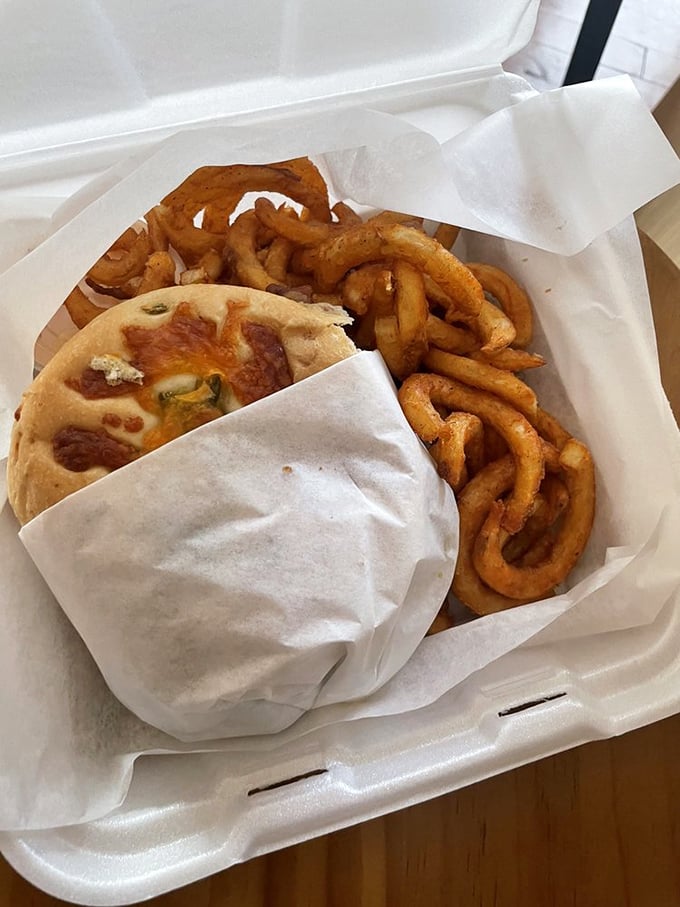 A sandwich that knows its worth, nestled beside curly fries that dance their way to flavor town. Simple food done extraordinarily well.