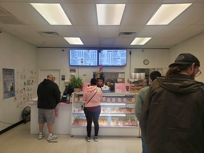 The morning pilgrimage to the donut counter – a ritual as old as time itself. These customers know that good things come to those who wait.