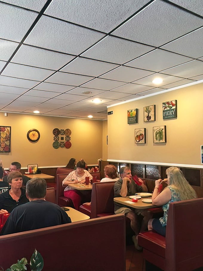 The dining room hums with the authentic rhythm of community—where regulars and newcomers alike find comfort in red booths and familiar conversations.