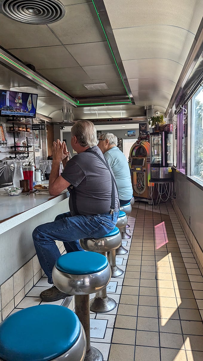 The counter is where the real diner magic happens. These gentlemen know exactly what they're doing—they've been practicing this ritual for decades.