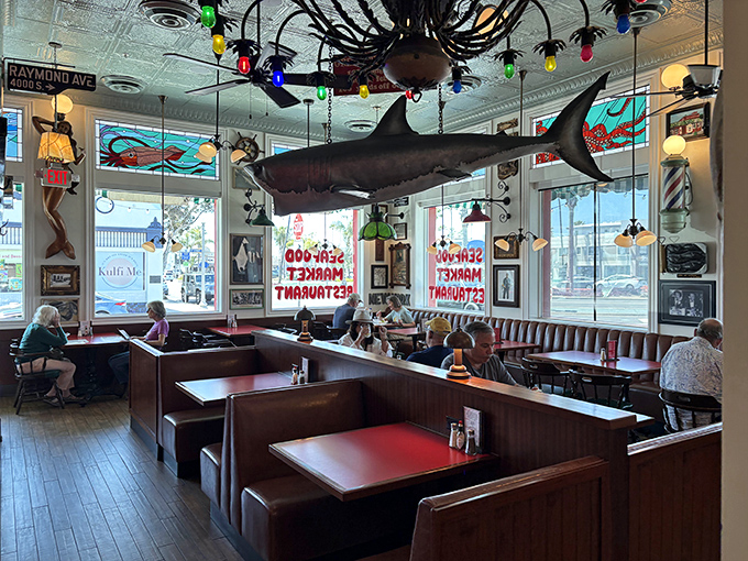 A suspended shark watches over diners like the friendly guardian of this seafood sanctuary. Under its watchful eye, every meal becomes an oceanic celebration.