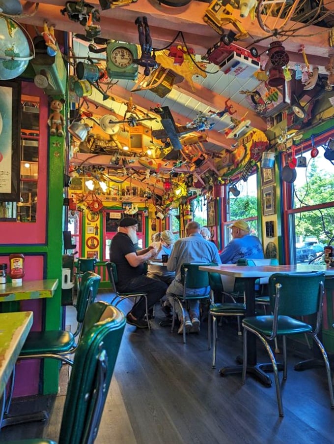 Diners enjoy their meals beneath a ceiling where childhood toys have formed their own gravity-defying community—conversation starter included at no extra charge.
