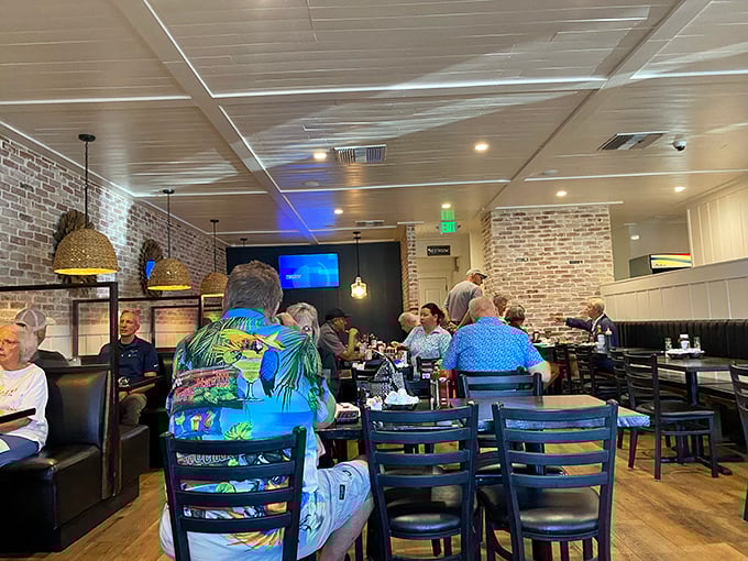 The dining room hums with the satisfied murmurs of locals and tourists alike. That shirt says it all – Florida living at its finest.