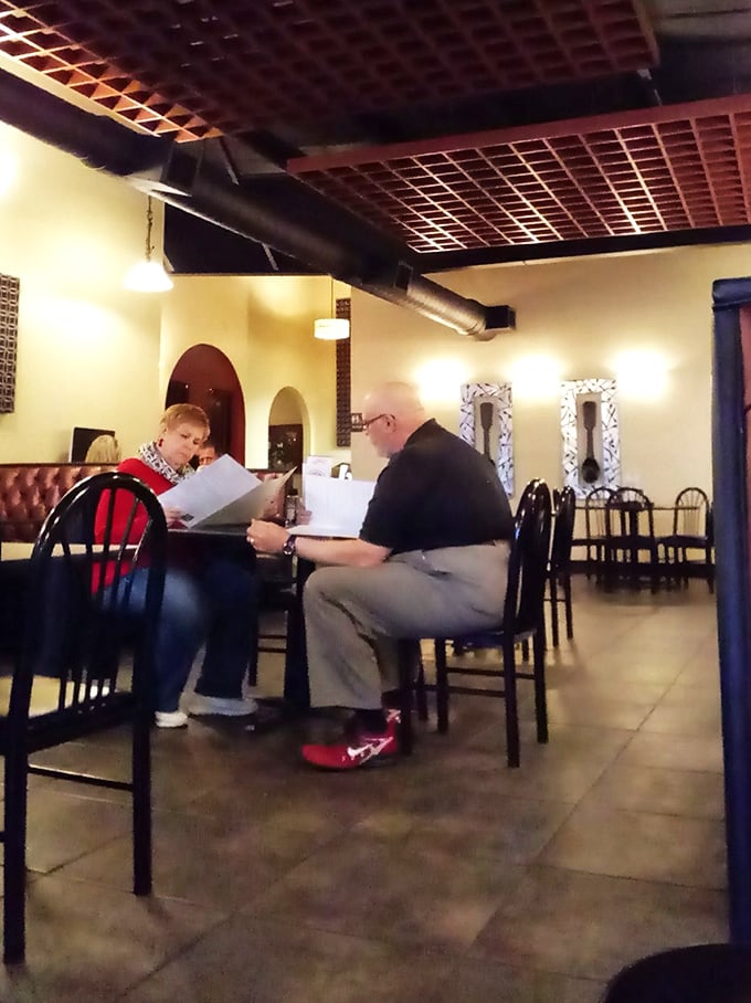 The quiet intensity of menu contemplation—a sacred moment when diners silently debate between the tried-and-true favorite or the tempting daily special.