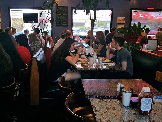 A bustling dining room where strangers become temporary tablemates, united by the universal language of "that looks amazing—what did you order?"