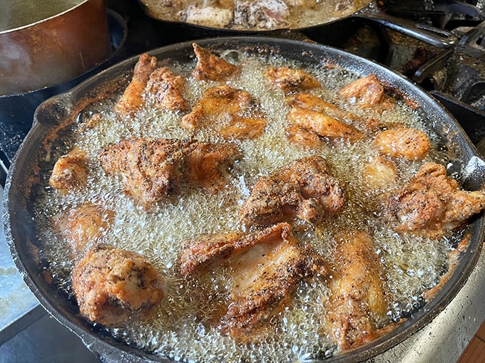 Culinary alchemy in progress – chicken pieces bubbling in their golden bath, transforming from ordinary to extraordinary right before your eyes.
