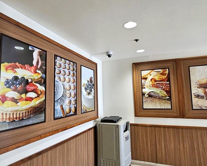 The wall art serves as a gallery of temptation, showcasing food photography that should come with a "may cause spontaneous ordering" warning.