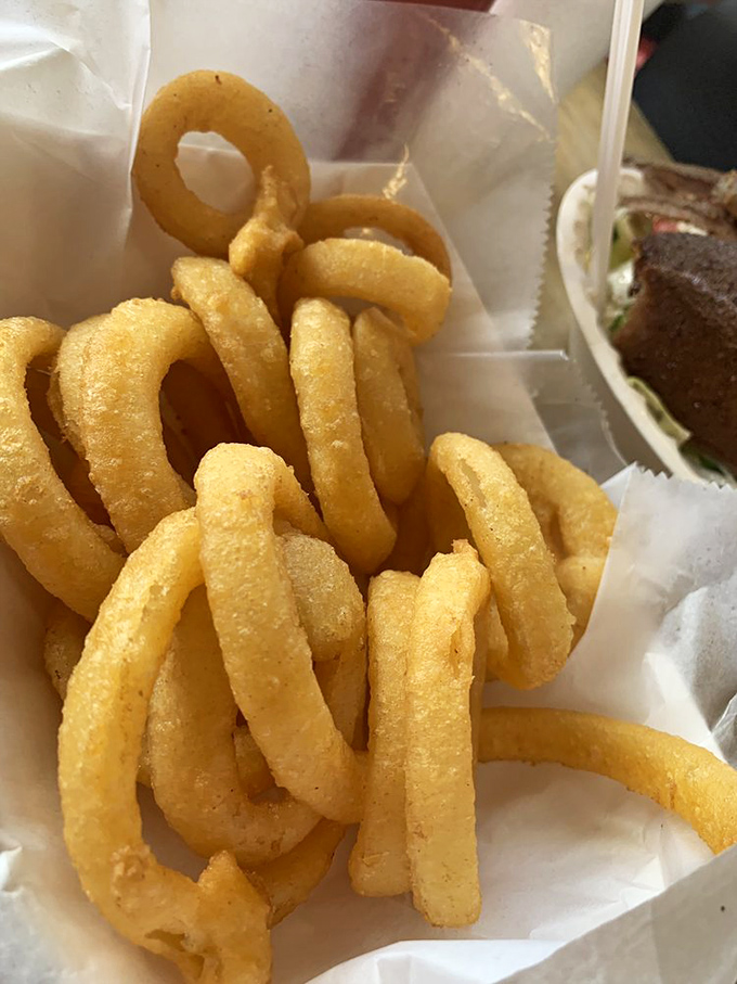 These golden halos of happiness aren't just onion rings—they're crunchy, savory treasures that make you temporarily forget about the beach outside.