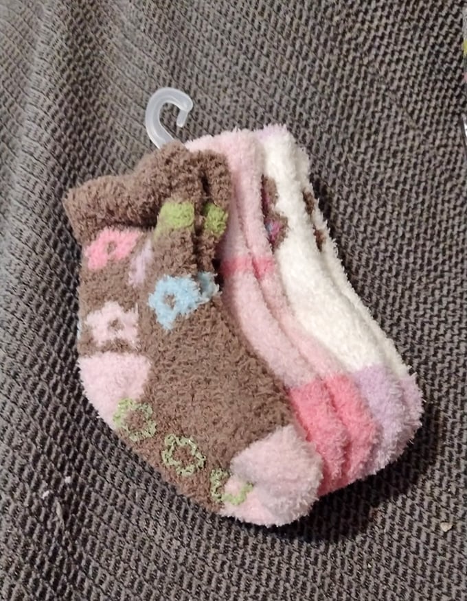 Fuzzy socks with forgotten histories hang ready for new adventures—perfectly priced for Michigan's notorious winter chill or quirky gift exchanges.