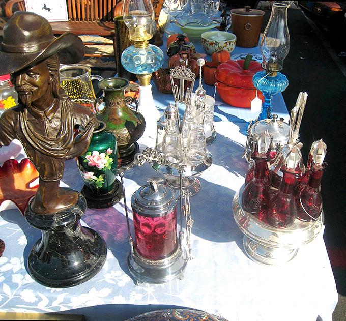 This table tells a hundred stories—from that John Wayne bust to the delicate oil lamps. Each piece waiting for its next chapter in someone else's home.