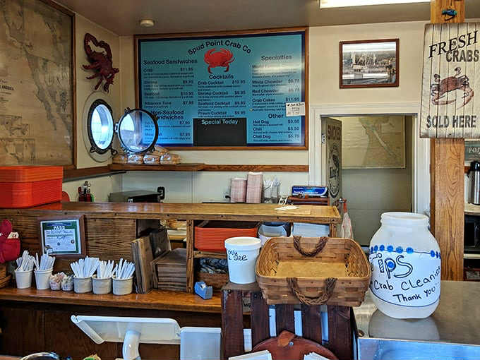Inside this nautical treasure chest, the menu board promises seafood nirvana while tip jars and maritime maps remind you this is the real deal.