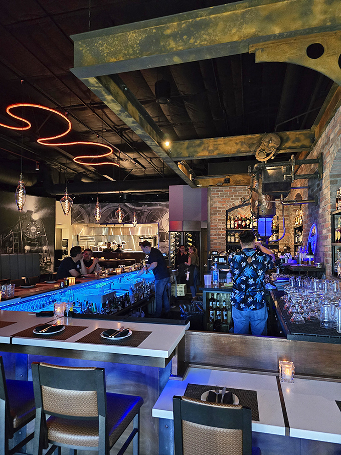 The contemporary bar glows with blue light. Where traditional steak craftsmanship meets modern cocktail artistry.