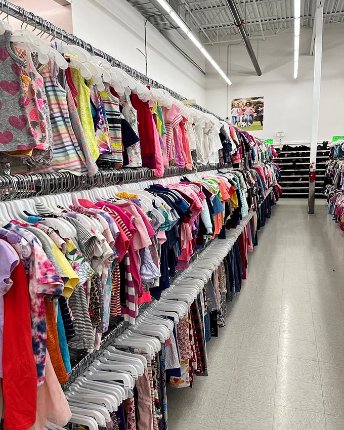 Rainbow rows of children's clothes at Village Discount – where growing kids and shrinking budgets find harmony.
