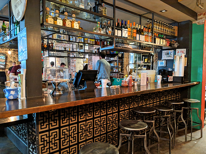 The bar isn't just where drinks are made—it's command central for flavor operations, with bottles standing at attention like soldiers ready for delicious duty.