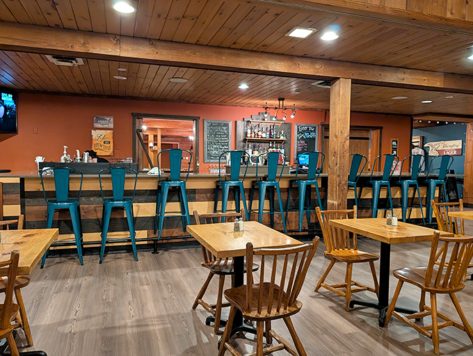 The bar area's turquoise stools pop against the wooden backdrop like little islands of cool in a sea of rustic charm.