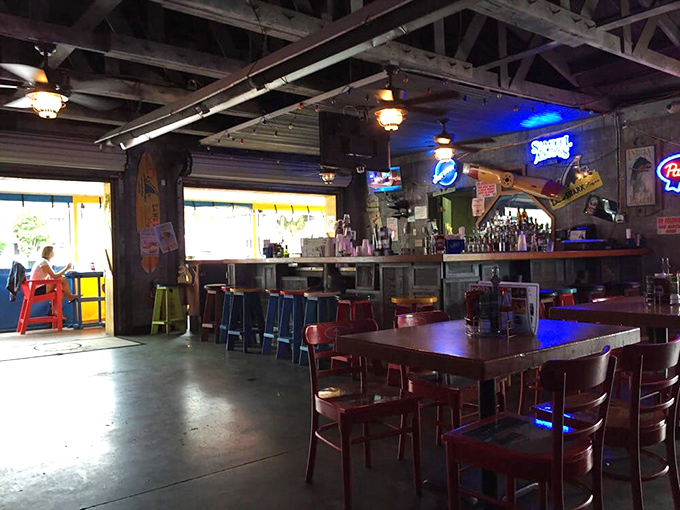 The bar area glows with neon signs and cold beer promises – a perfect refuge when your skin says "enough sun for today."