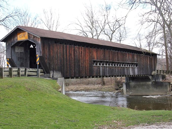Benetka Road Covered Bridge stands as a weathered wooden sentinel, its timbers telling tales of horse-drawn carriages and Sunday afternoon drives.
