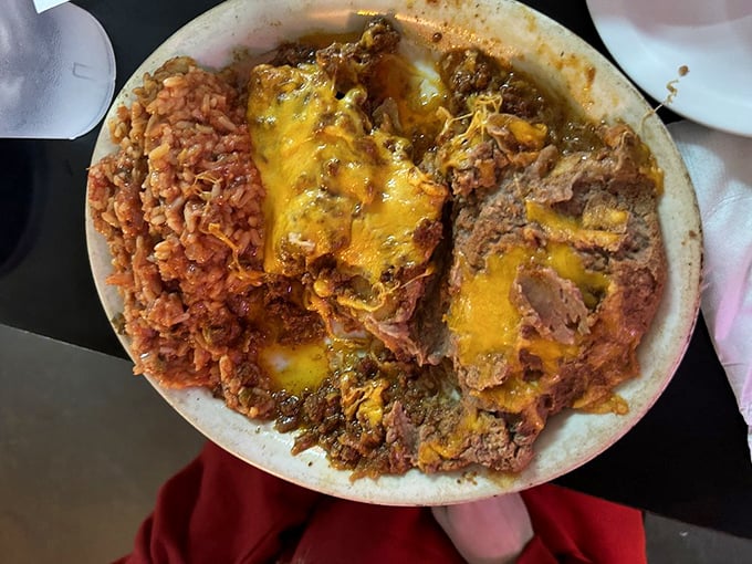 These enchiladas don't just get covered in cheese—they practically disappear beneath it, creating that beautiful Tex-Mex magic where everything melts together in perfect harmony.