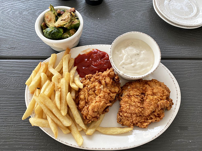 The holy trinity of comfort food: golden fried chicken, perfectly cooked fries, and sides that remind you why eating out beats cooking any day.