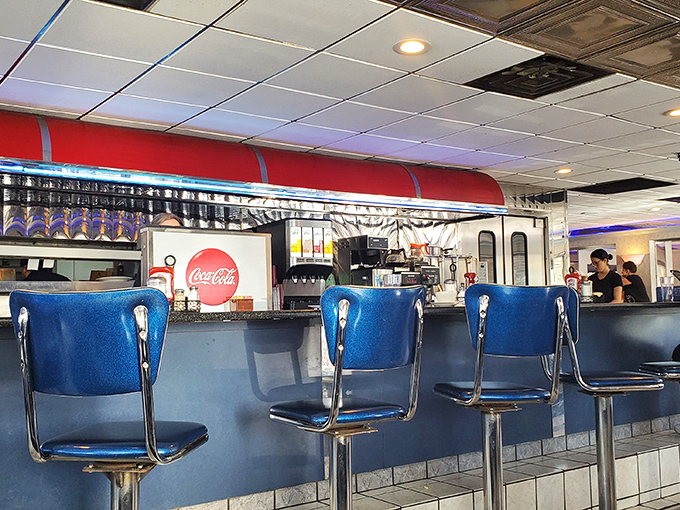 Blue counter seats—front-row tickets to the greatest show on earth: short-order cooks turning ordinary ingredients into extraordinary memories.