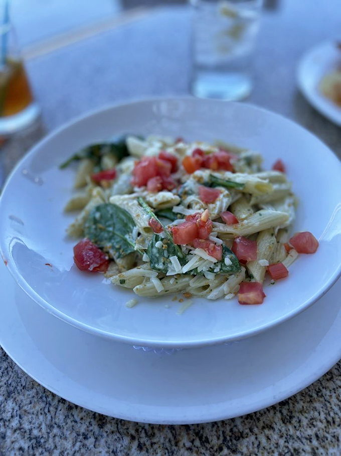 Pasta that doesn't just sit on the plate—it performs, with fresh tomatoes and greens playing supporting roles to perfection.