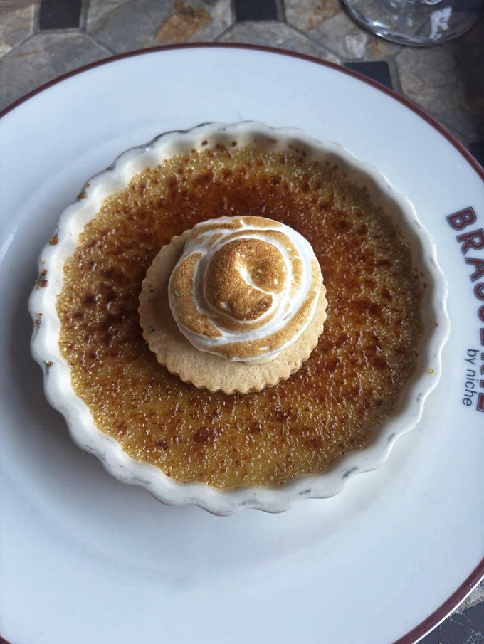 This crème brûlée with its perfectly torched top cracks like thin ice on a winter pond, revealing silky custard treasure below.