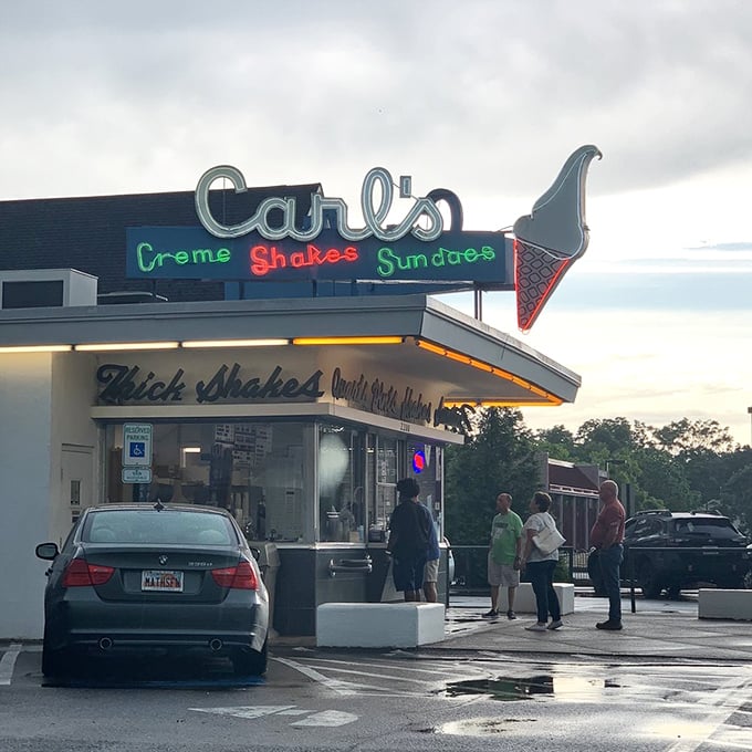 The neon glow of Carl's at dusk transforms an ice cream stop into something more profound—a pilgrimage to a temple of frozen delight.