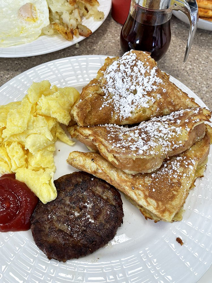 French toast that puts ordinary bread to shame, dusted with powdered sugar and flanked by eggs and sausage. Breakfast of champions—and everyone else.