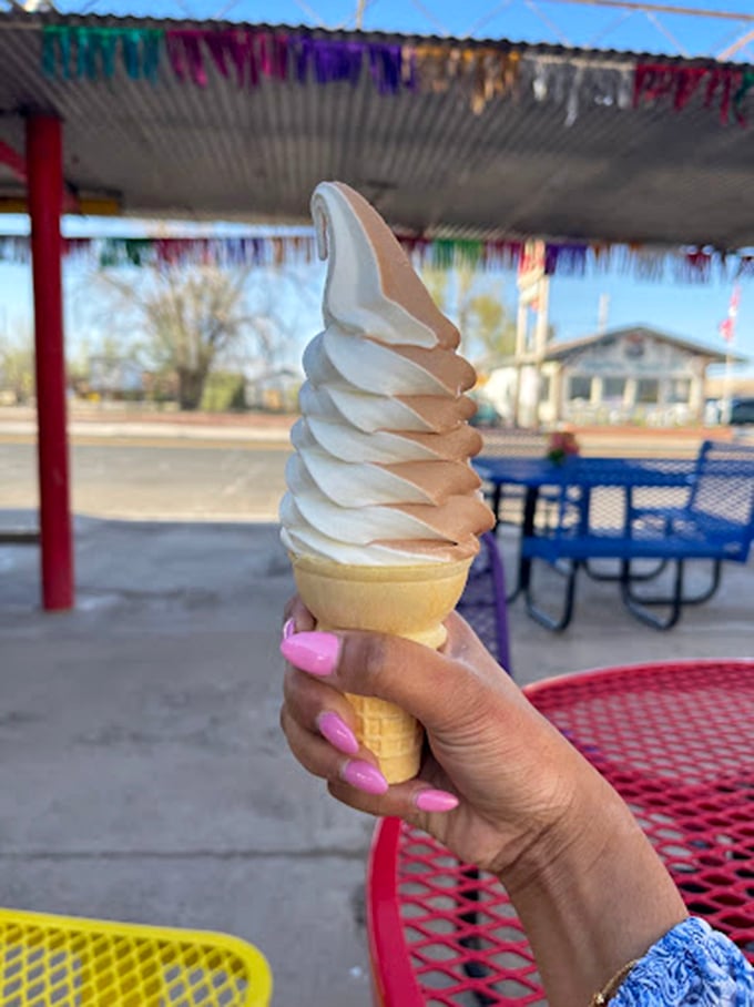 Soft-serve perfection that stands tall and proud, a beacon of creamy delight against the Arizona sky and colorful picnic tables.
