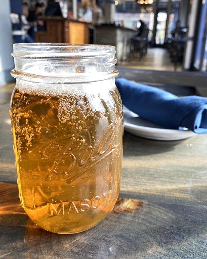 Beer served in a mason jar—because Southern hospitality demands proper glassware be optional. Cold, amber, and ready for sipping between bites.