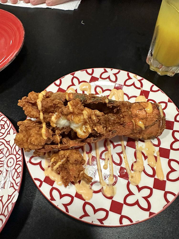 This isn't just fried lobster – it's crustacean transformation. Crispy exterior giving way to sweet meat, with sauce artfully drizzled like culinary calligraphy.