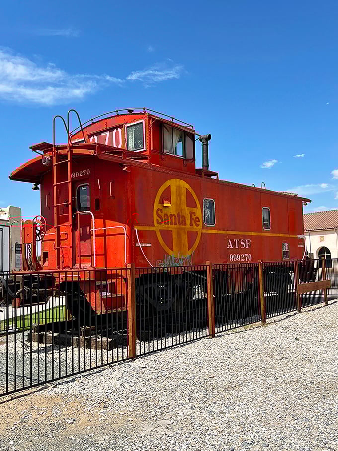 The mighty Santa Fe caboose stands guard outside, a crimson reminder of when railways and highways competed for America's heart.