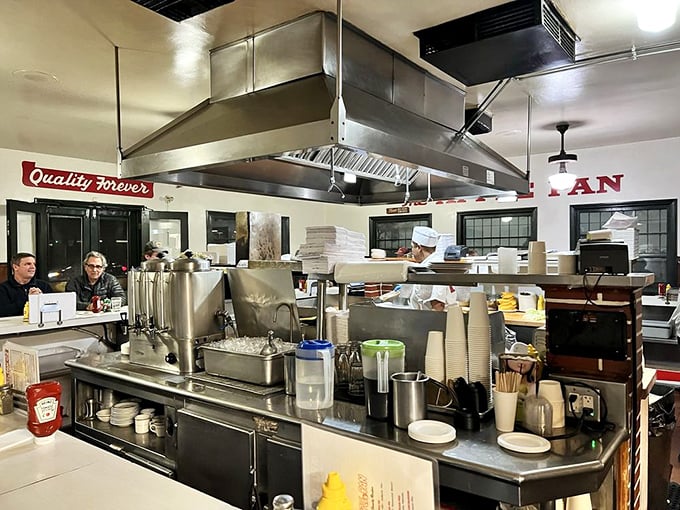 The open kitchen layout isn't a modern design choice – it's how they've always done it, letting you watch your burger's journey from patty to perfection with nothing to hide.