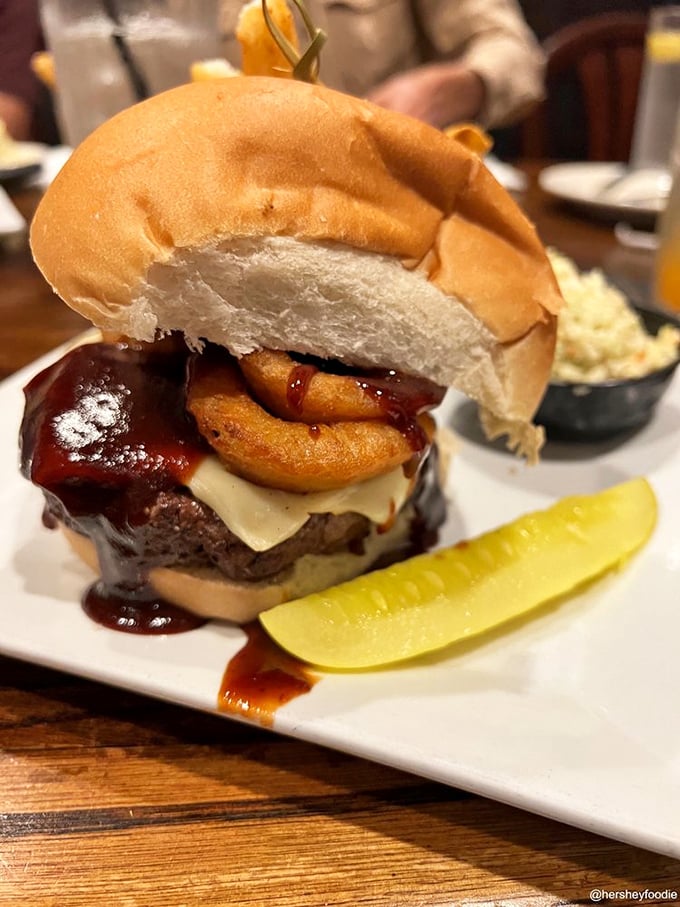 The Rodeo Burger defies gravity with its towering onion rings and BBQ sauce. A delicious architectural challenge worth accepting.