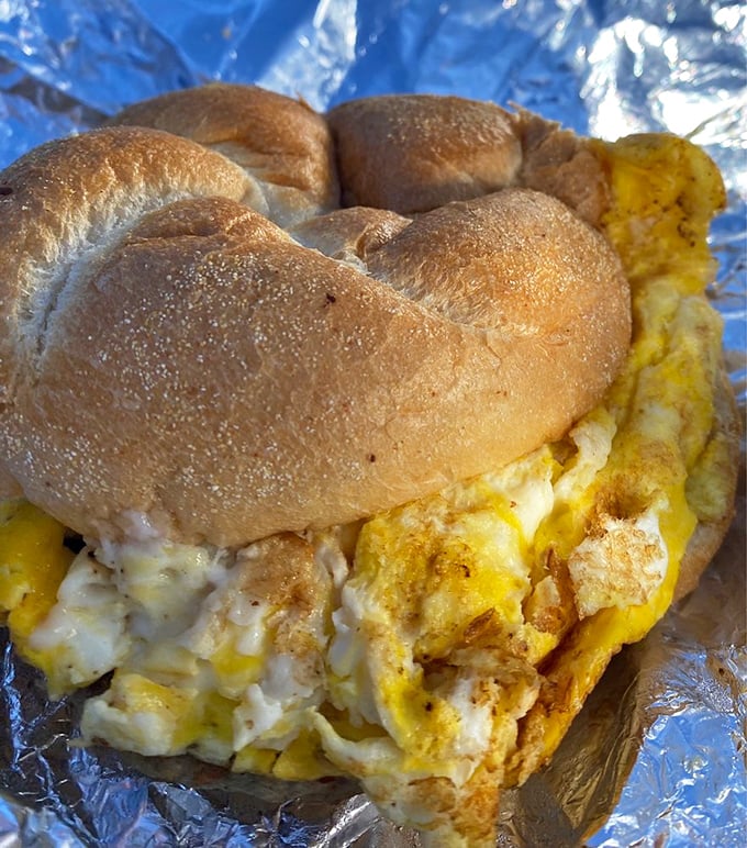 Morning salvation on aluminum foil—where fluffy eggs and savory sausage create the breakfast of champions and hangover heroes alike.