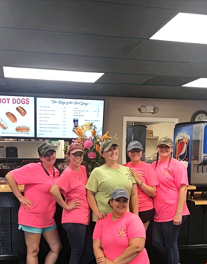 The team behind the legend—these ladies in pink shirts are the keepers of the flame, guardians of a hot dog tradition that spans generations.