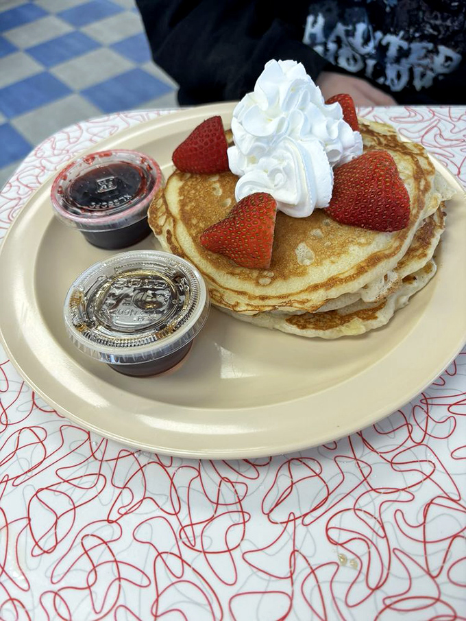 Pancakes crowned with fresh strawberries and whipped cream—the breakfast equivalent of putting on a tuxedo just because it's Tuesday