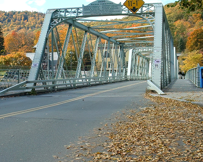 Autumn leaves scatter across the truss bridge like nature's confetti, celebrating another spectacular fall in the Berkshires.
