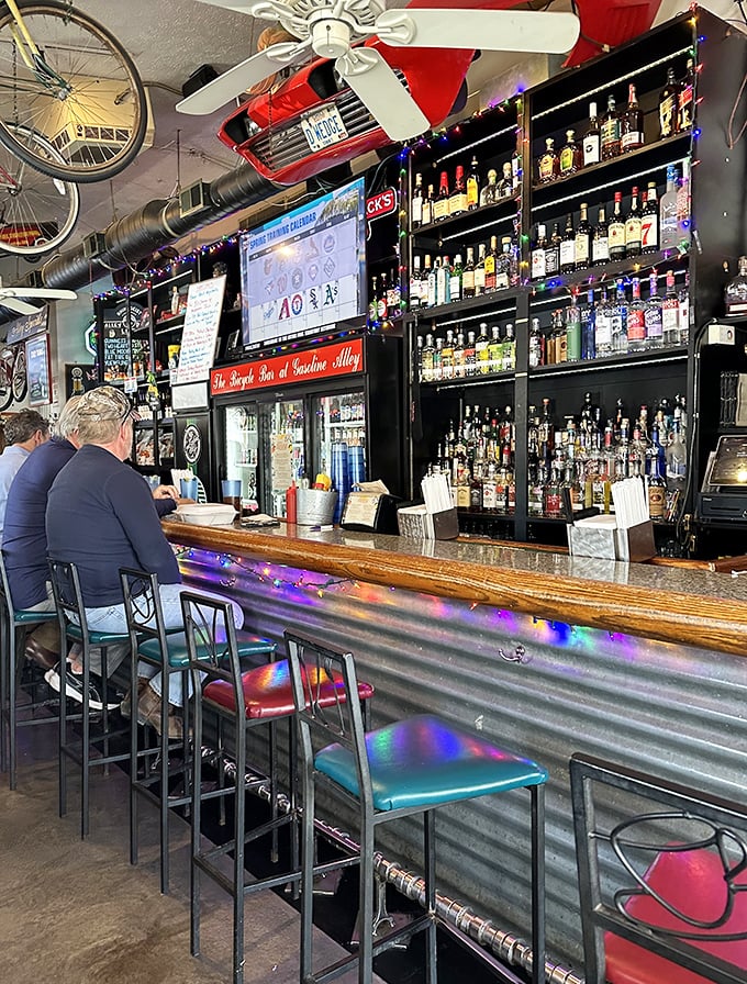 The bar at Gasoline Alley isn't just stocked—it's a liquid library of possibilities. Colorful lights add to the festive atmosphere of culinary celebration.