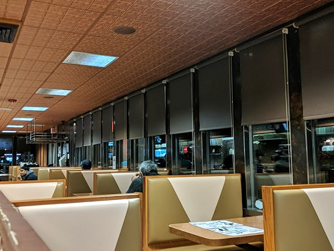 Classic booths line up like old friends waiting for conversation—their cream vinyl seats having heard decades of first dates, family meals, and late-night confessions.