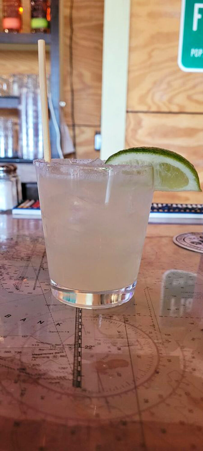 Clear liquid, lime wedge, salt rim—this margarita isn't complicated, just completely perfect. Served atop what appears to be a nautical map, no less.
