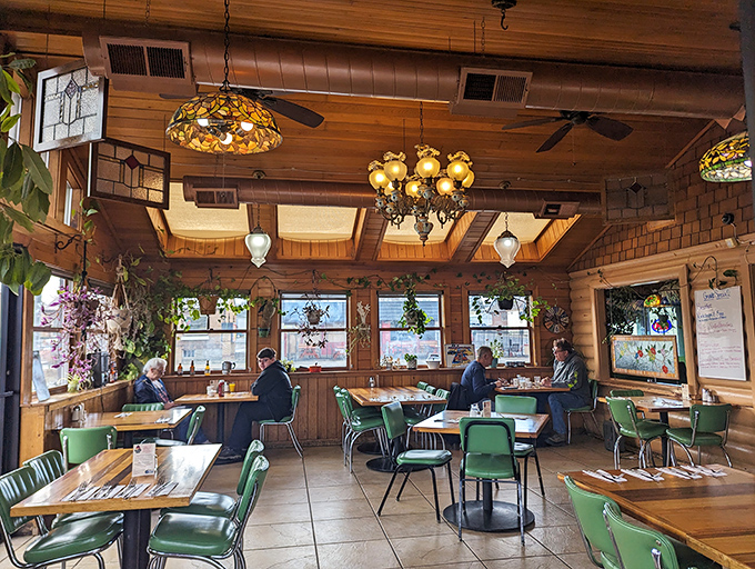 The dining room feels like a secret woodland retreat. Those green chairs have supported countless happy diners in their quest for comfort food.