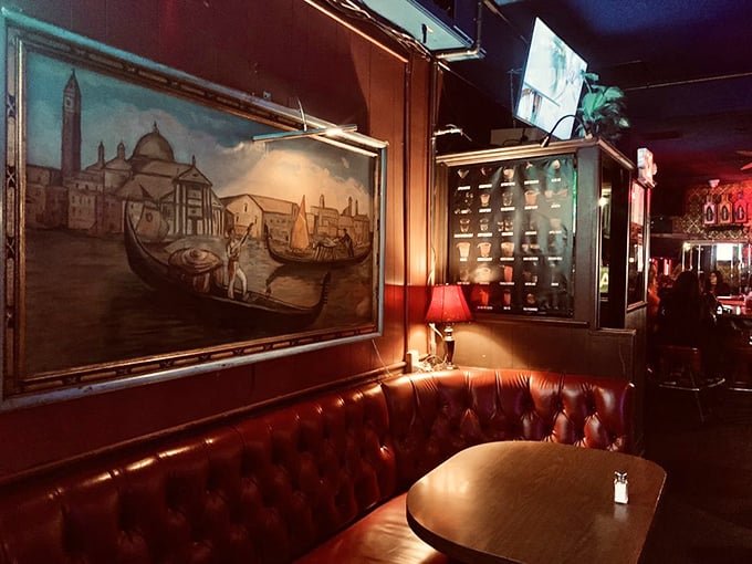 The red leather booth beneath Venetian artwork isn't just seating – it's a front-row ticket to the theater of nostalgia that plays nightly.