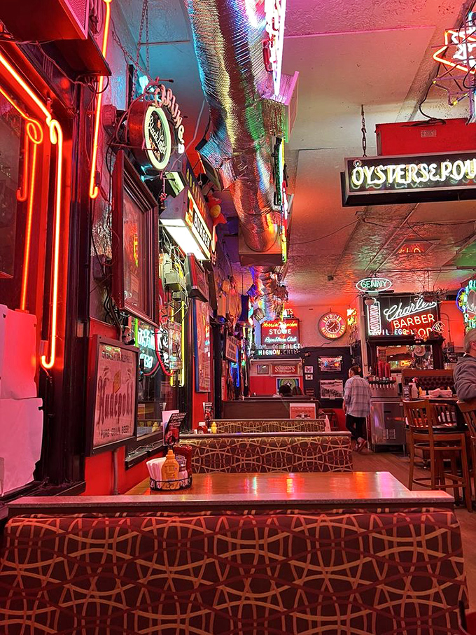 The neon glow transforms ordinary tables into front-row seats at the theater of comfort food. Every inch tells a story.