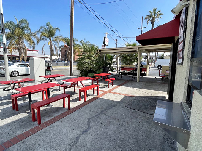 Red picnic tables under the California sun—simple, unpretentious, perfect. The stage is set for memories made between bites.