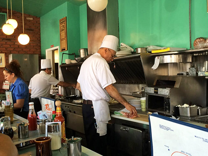 The white-hatted kitchen maestros move with practiced precision—there's no molecular gastronomy here, just decades of breakfast-making wisdom in action.